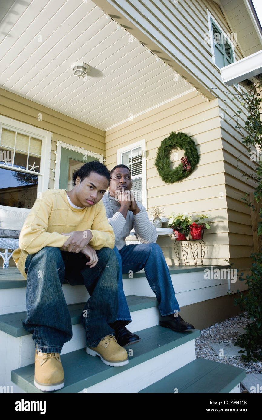 Portrait of father and son sitting on steps of porch Stock Photo - Alamy