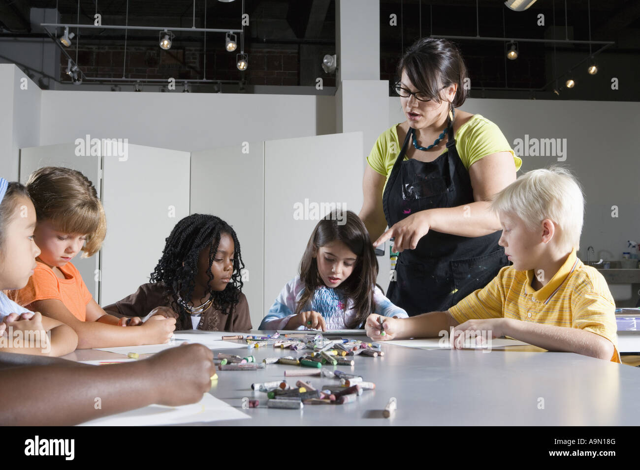 An art teacher teaching young students in art class Stock Photo - Alamy