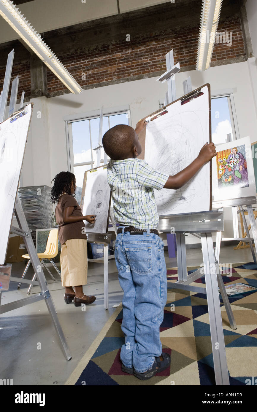 Young children drawing on easels in art class Stock Photo - Alamy