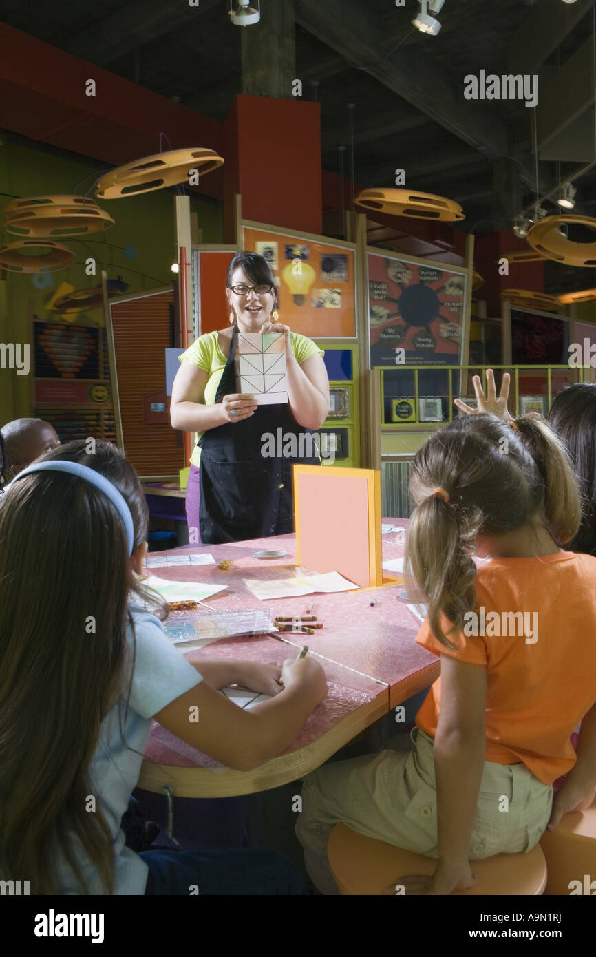 An art teacher teaching her young students in art class Stock Photo - Alamy
