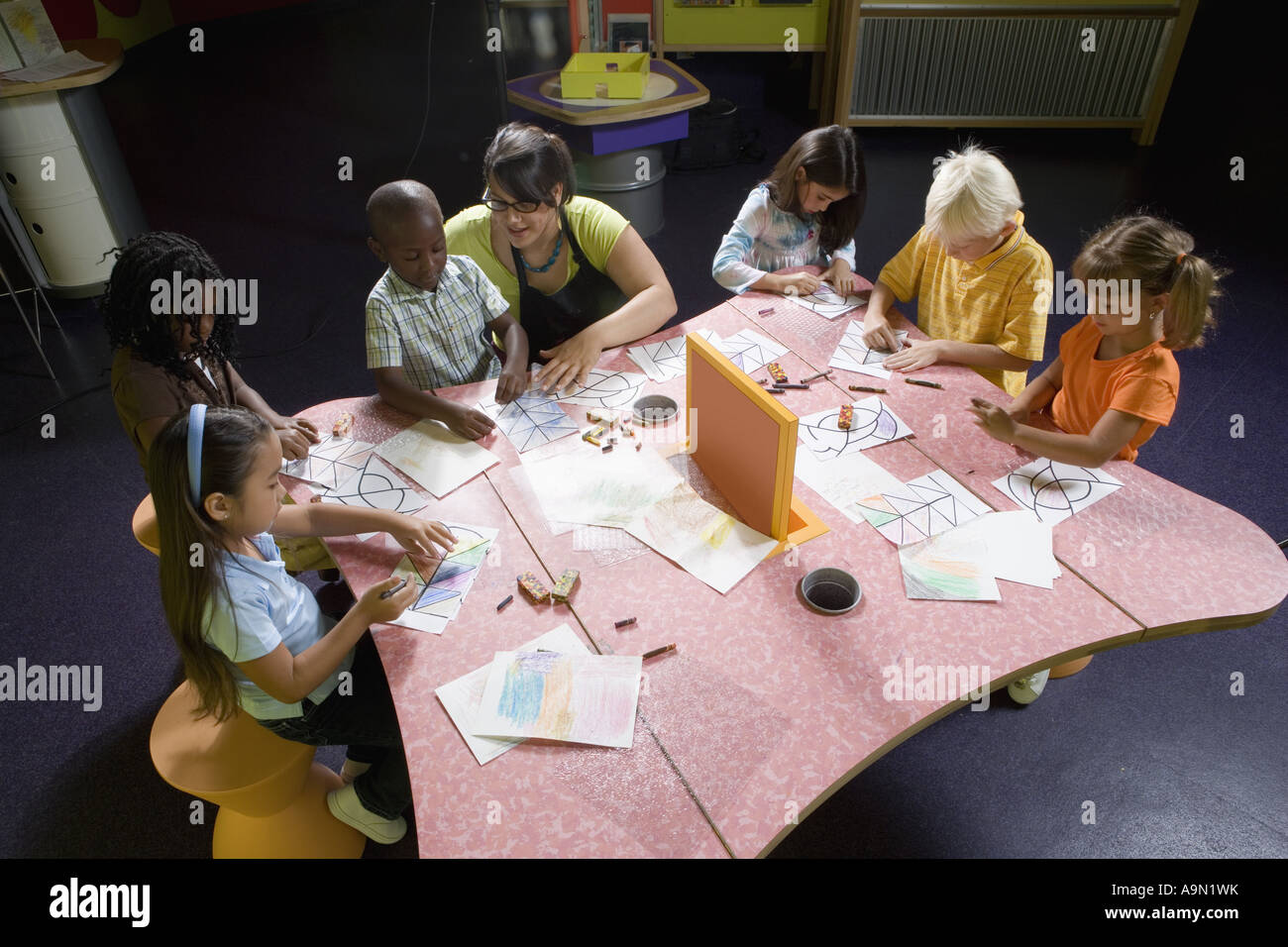 An art teacher teaching her young students in art class Stock Photo - Alamy