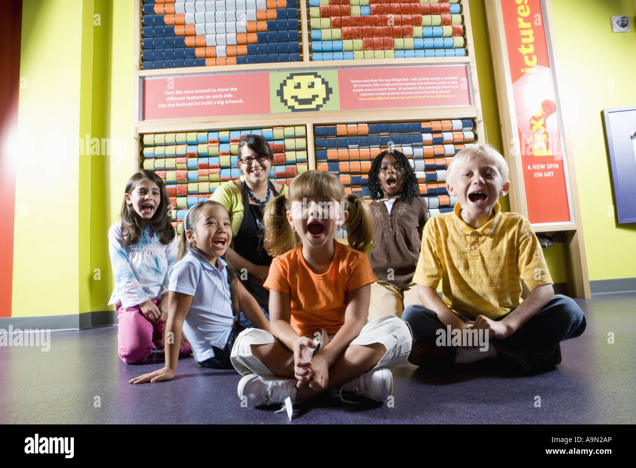 Teacher sitting with young children Stock Photo - Alamy