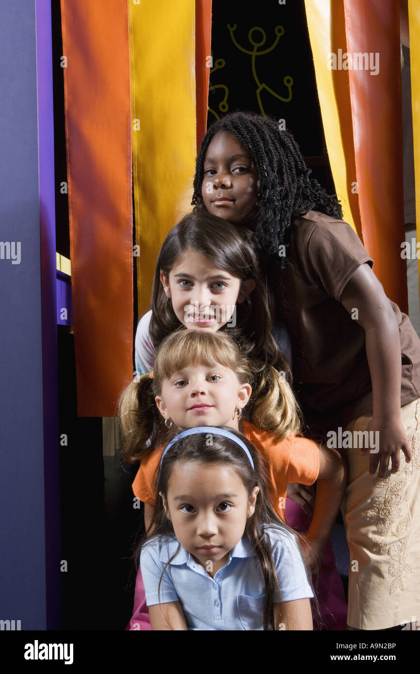 Four girls placing their heads in a vertical row Stock Photo - Alamy