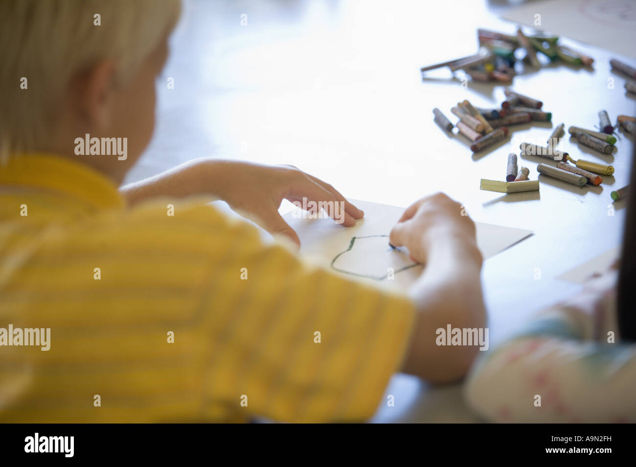 Close-up of a boy drawing with crayons Stock Photo - Alamy