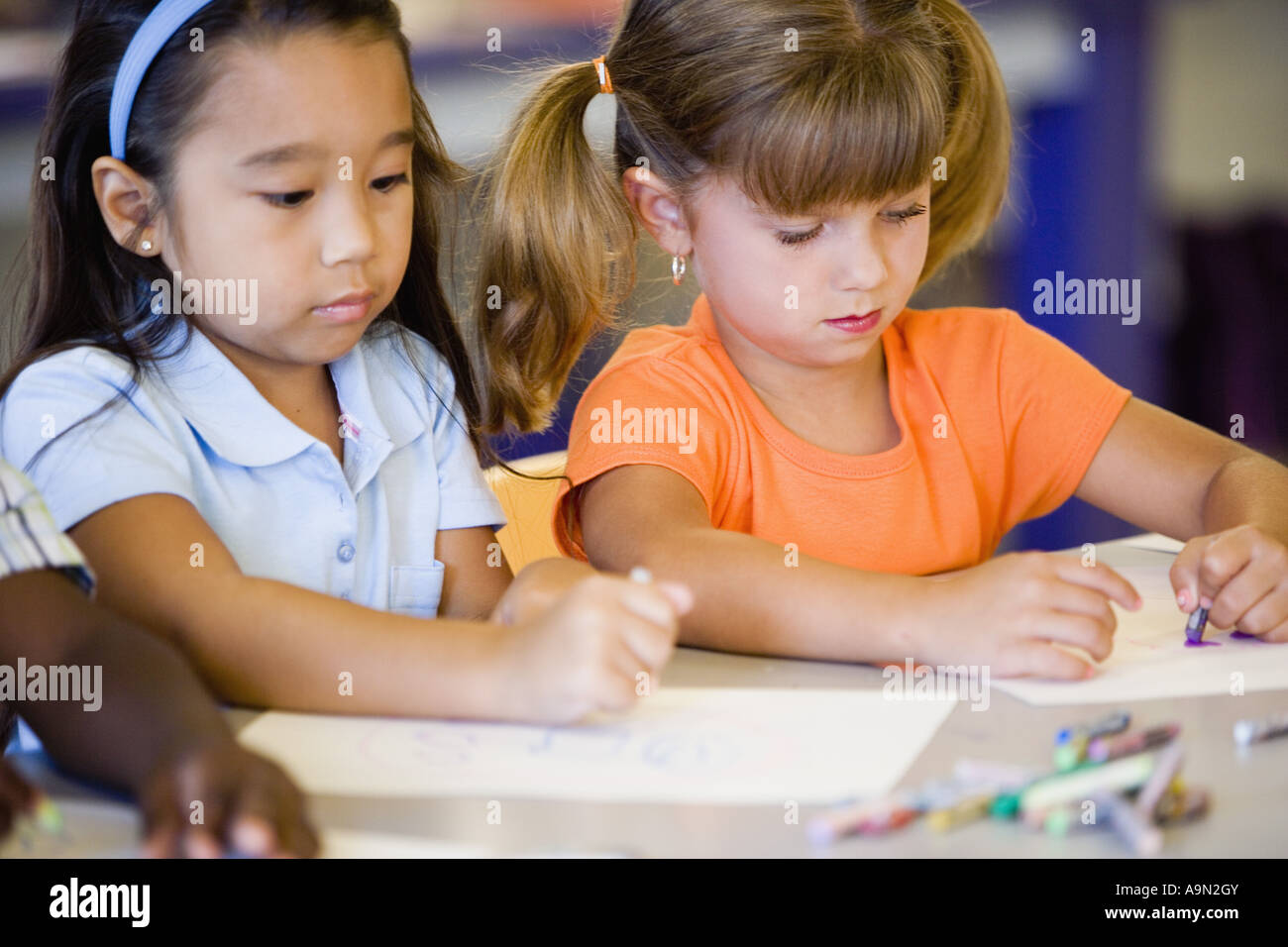 Girls drawing with crayons in an art class Stock Photo - Alamy