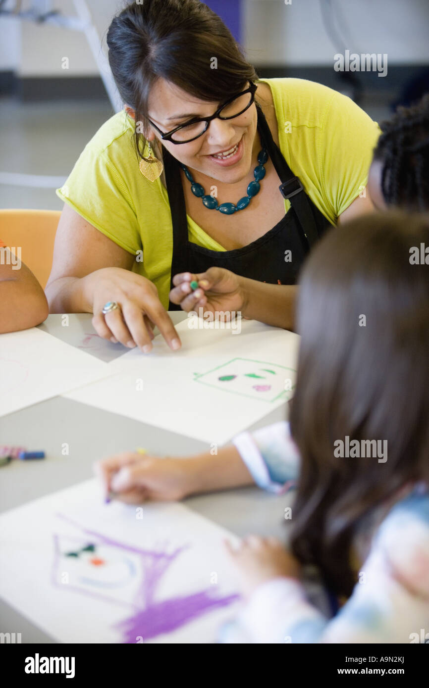 Close up of teacher helping young children in class Stock Photo - Alamy