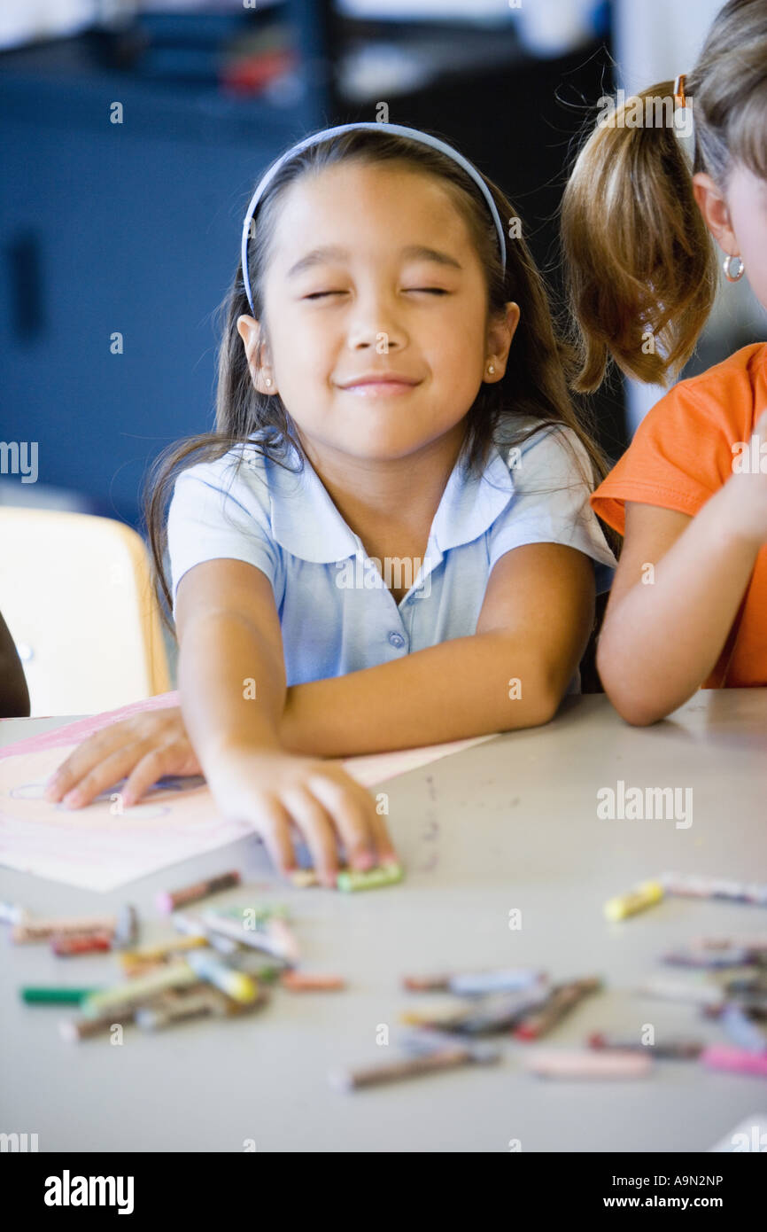 Little girl picking crayon with eyes closed Stock Photo - Alamy