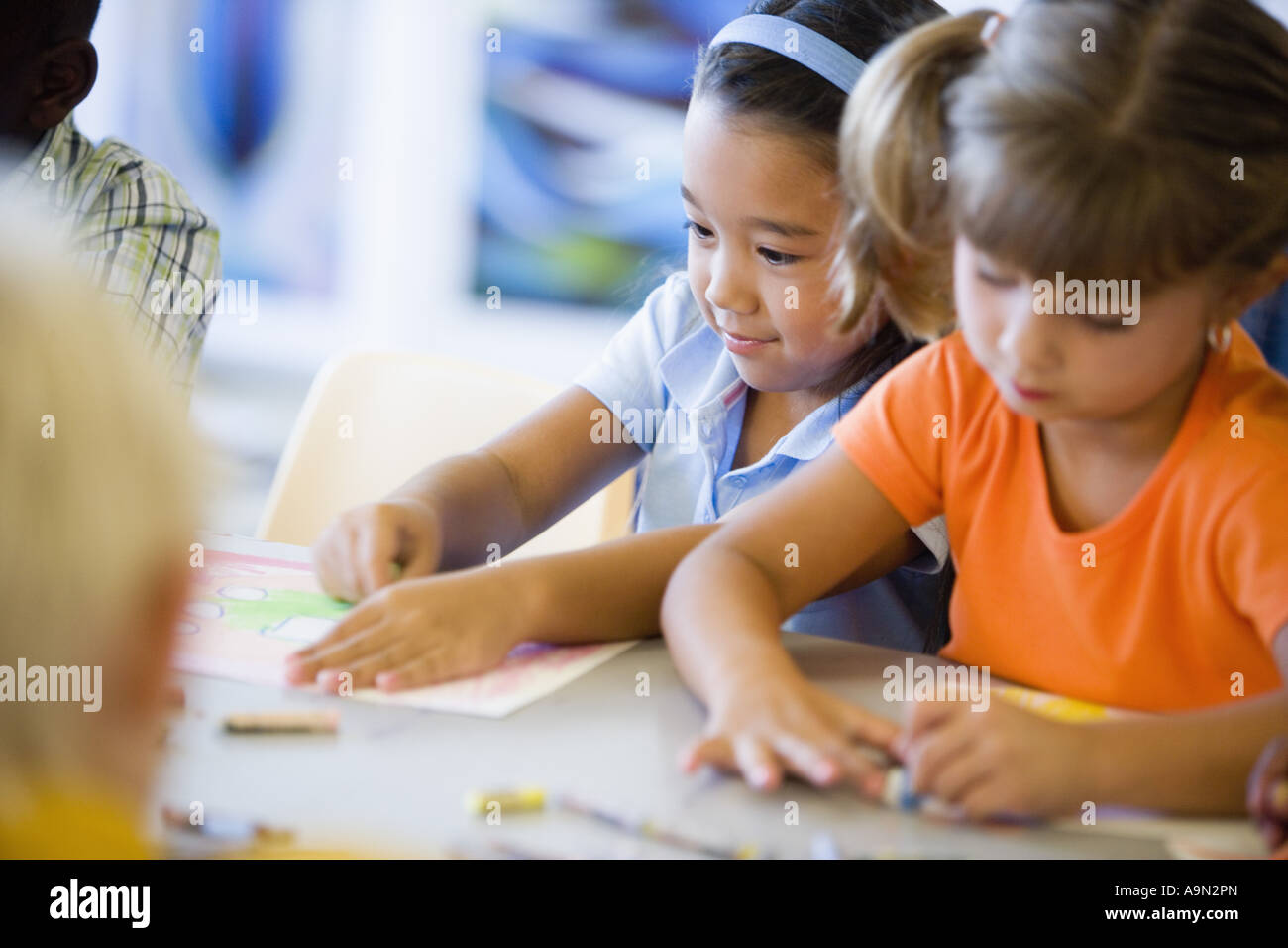 Girls drawing with crayons in an art class Stock Photo - Alamy