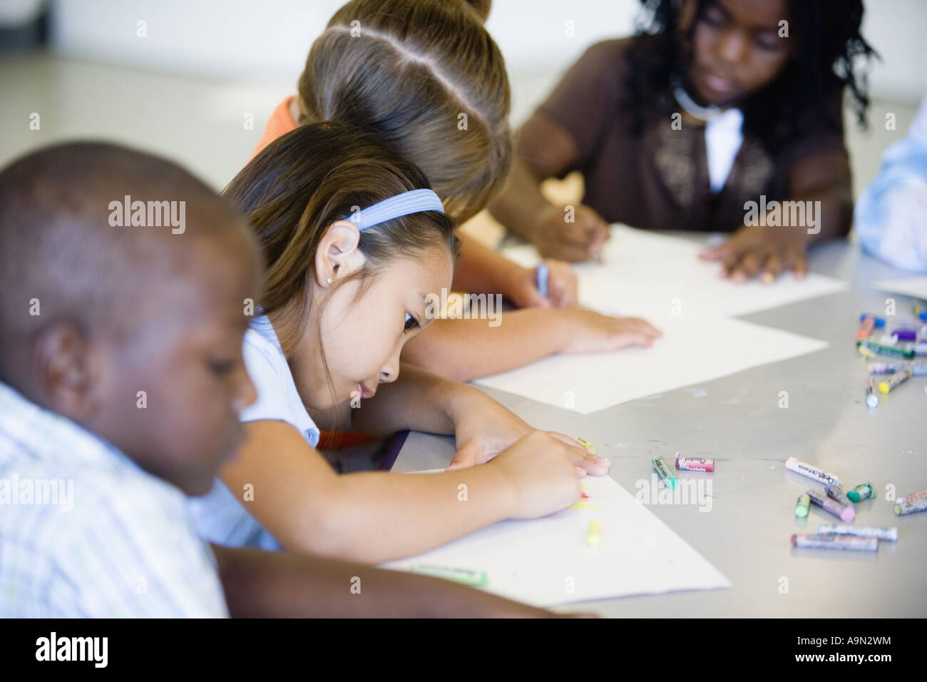 children drawing with crayons around a table Stock Photo - Alamy