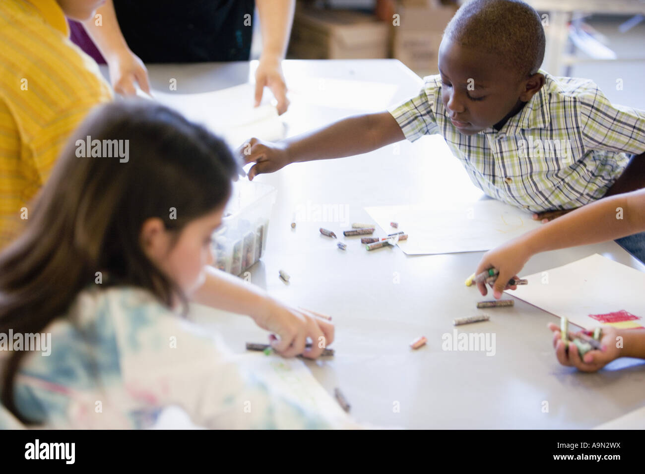 children drawing with crayons around a table Stock Photo - Alamy