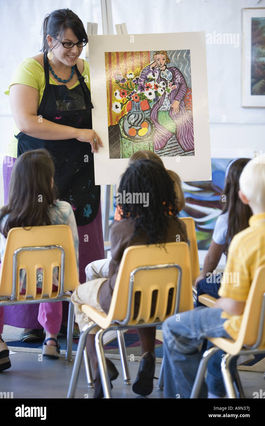An art teacher showing painting to young students in art class Stock ...