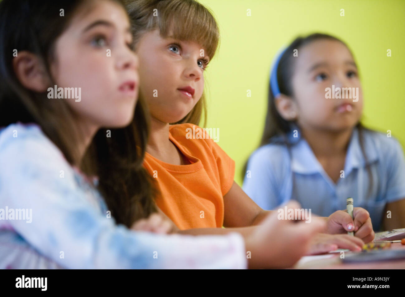 Young girls watching and listening attentively Stock Photo - Alamy