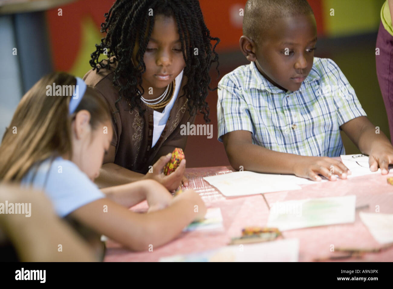 Three children coloring with crayons Stock Photo - Alamy