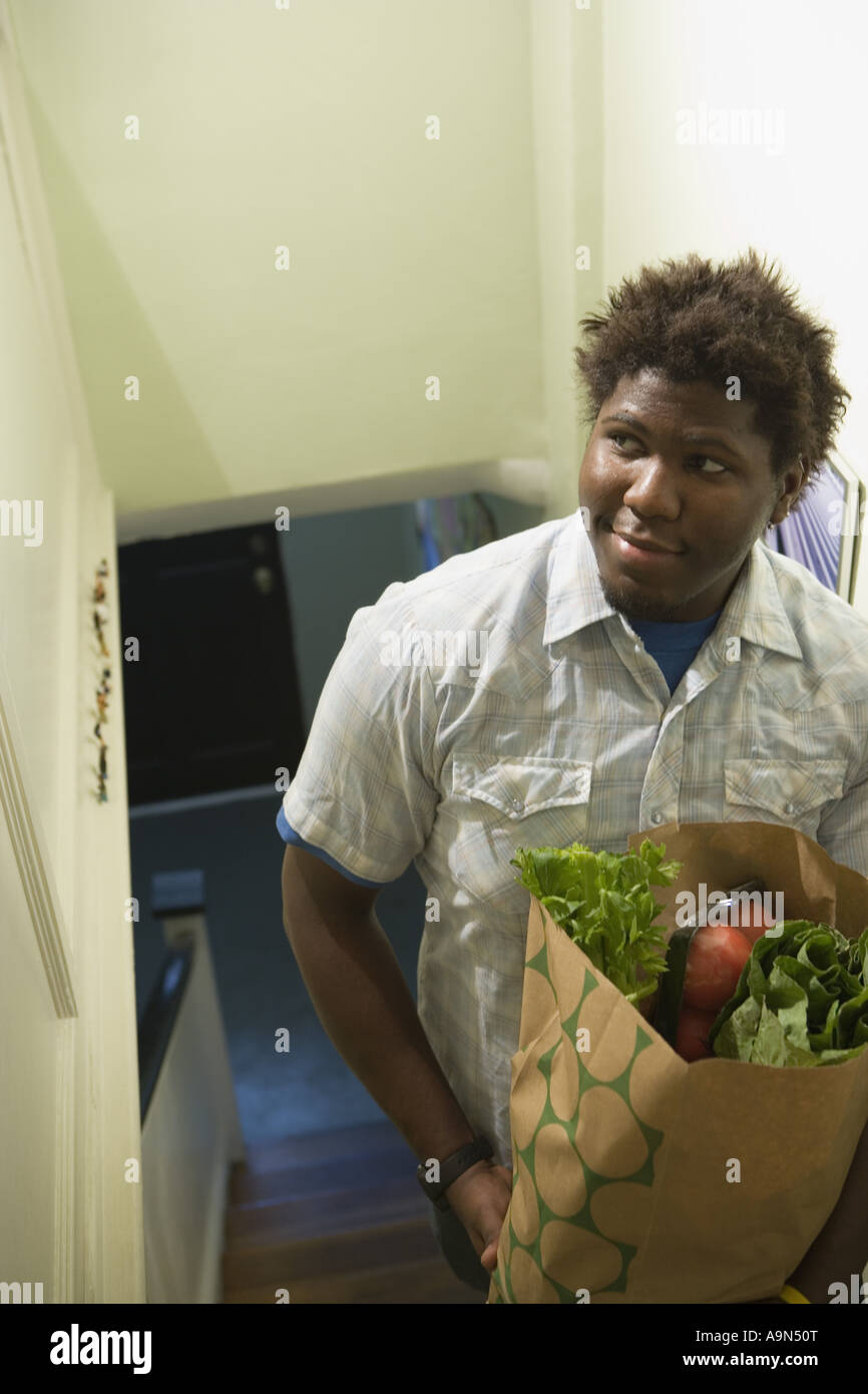 Man holding a grocery bag filled with groceries Stock Photo - Alamy