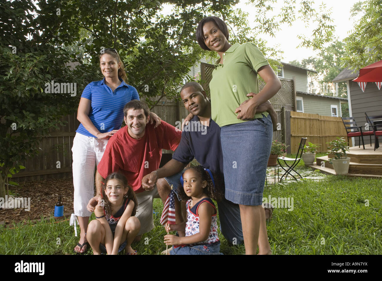 Portrait of two families standing together in backyard of house Stock ...
