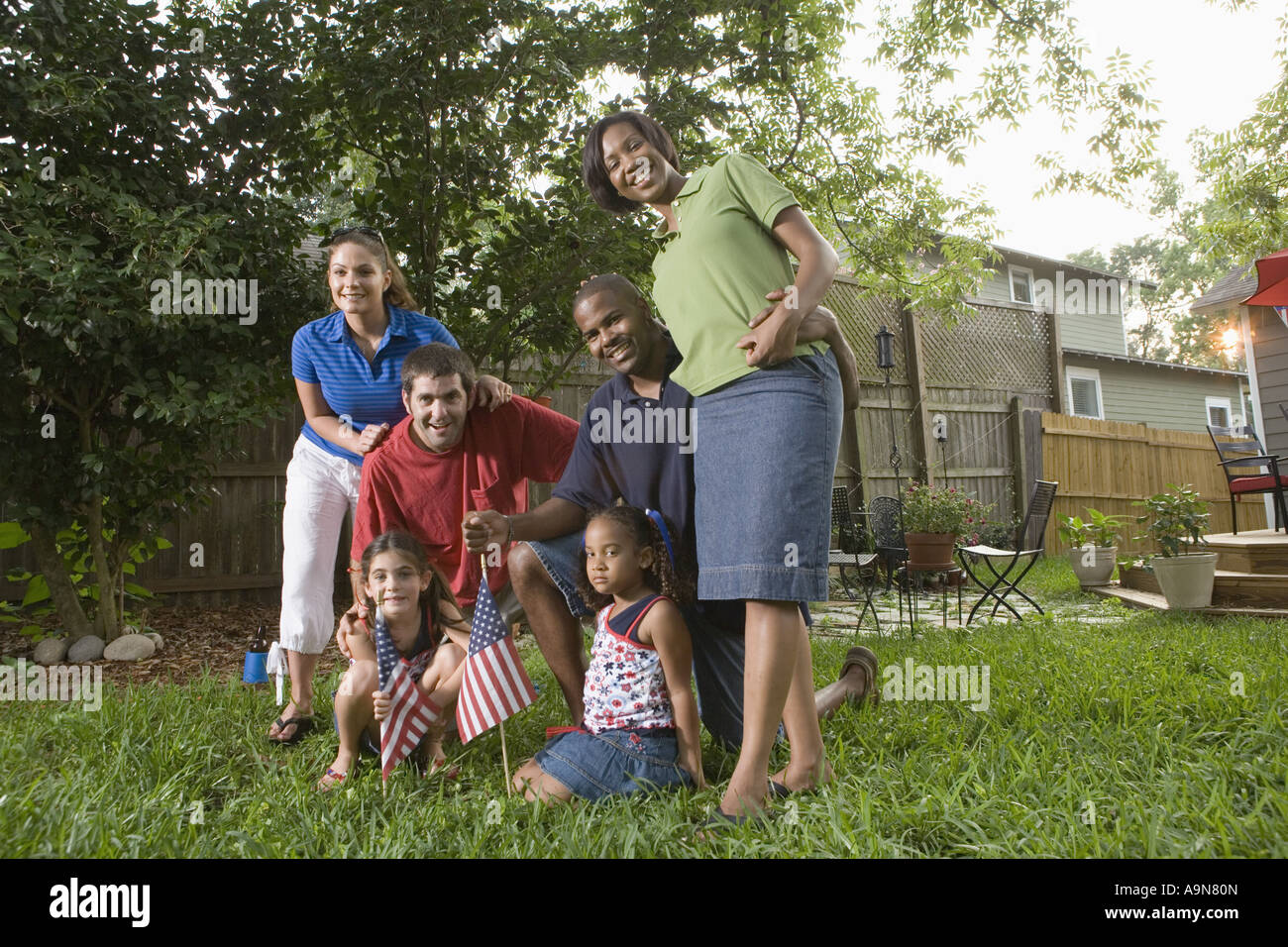 Portrait of two families standing together in backyard of house Stock ...