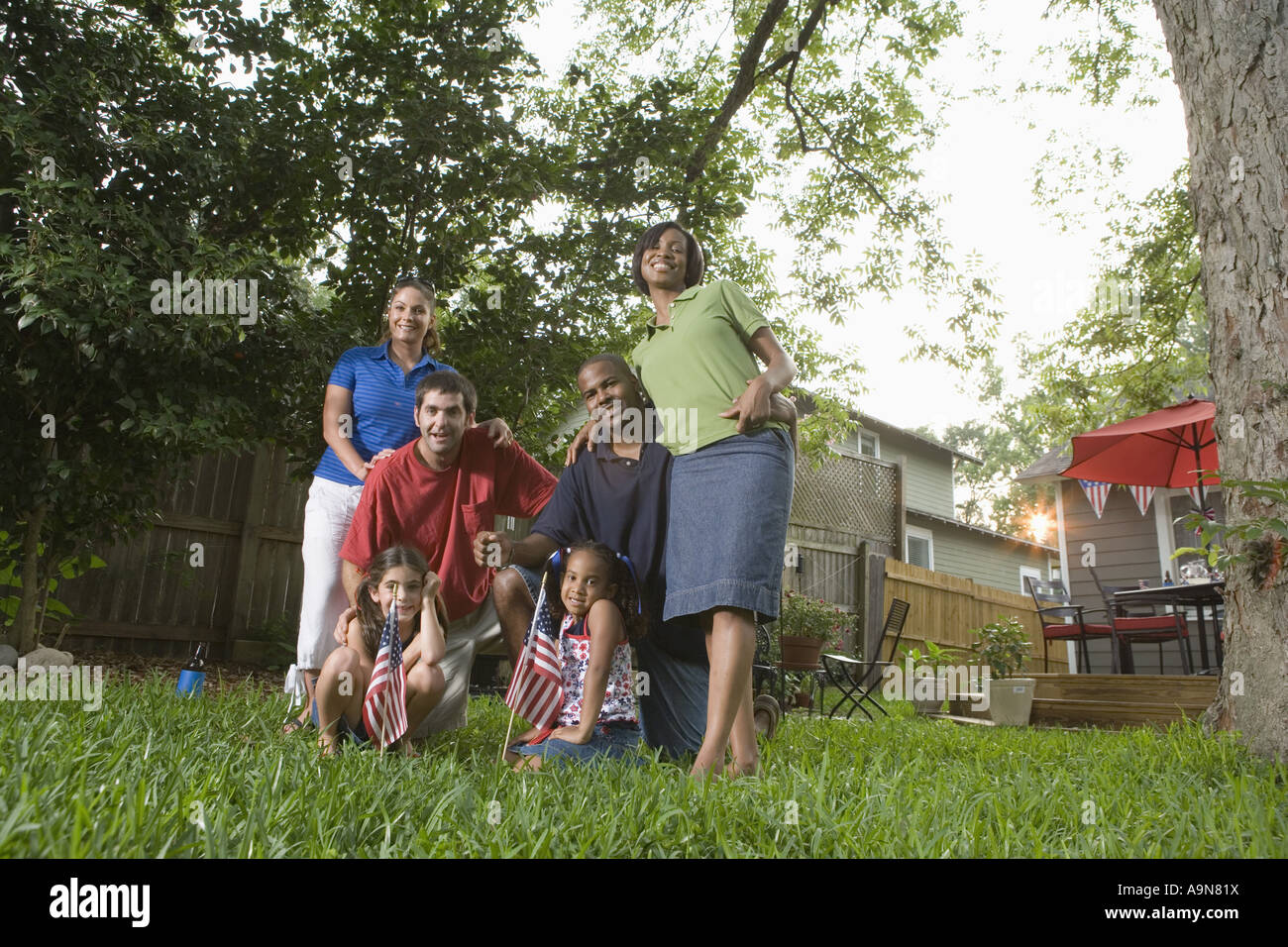 Portrait of two families standing together in backyard of house Stock ...