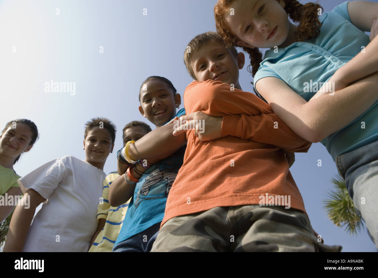 Low angle view of children with folded arms standing together at a ...