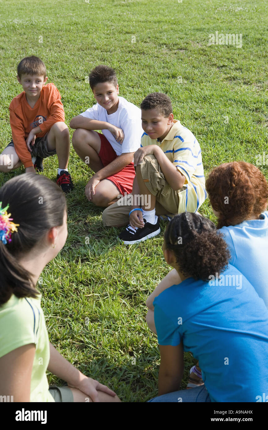Group of children kneeling on the grass Stock Photo - Alamy