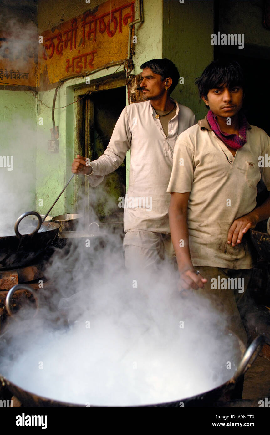 Men cooking traditional Indian style tea/chai in large pots at a street ...