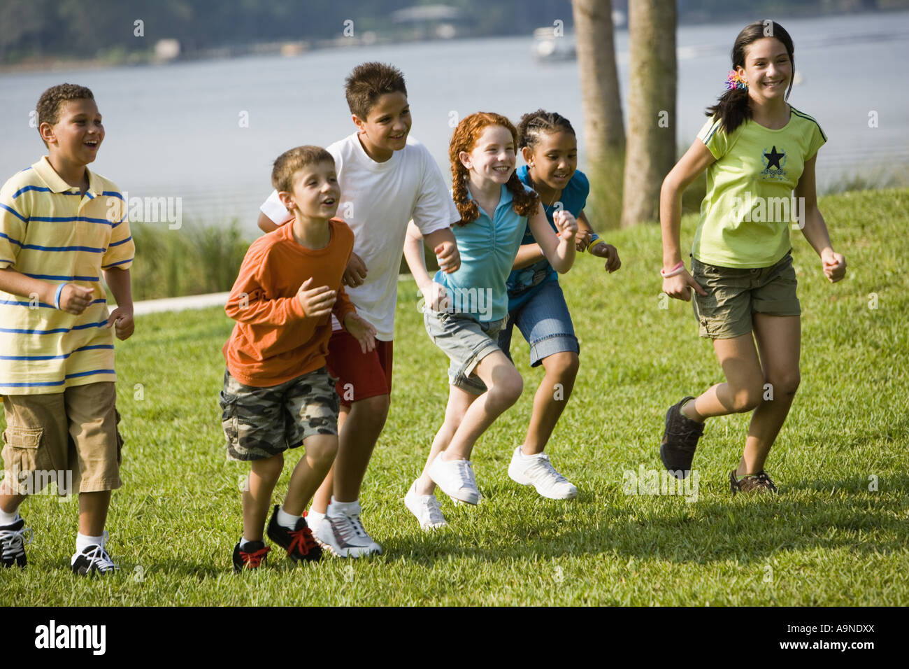 Boys and girls running side by side at a park Stock Photo - Alamy