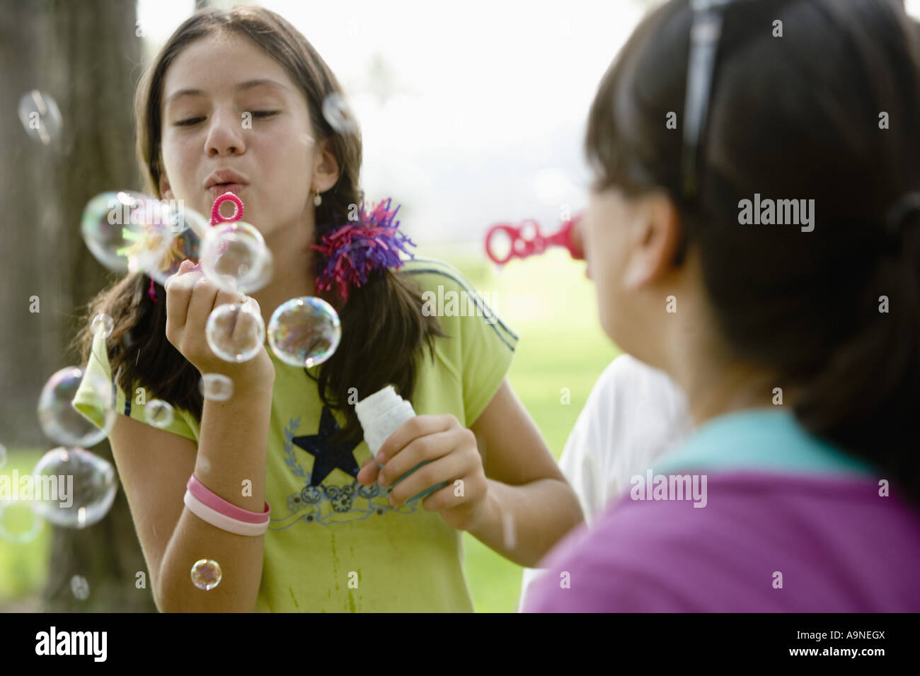 Children blowing bubbles at a park Stock Photo - Alamy