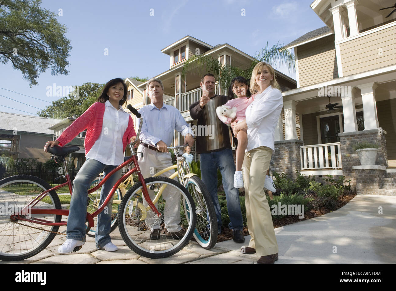 Family with young child conversing with neighbors in front of house ...