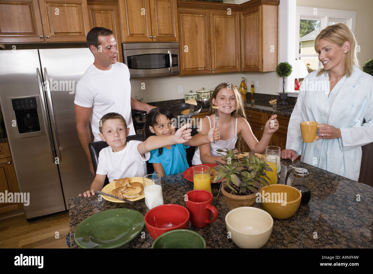 Family having breakfast in the kitchen Stock Photo - Alamy