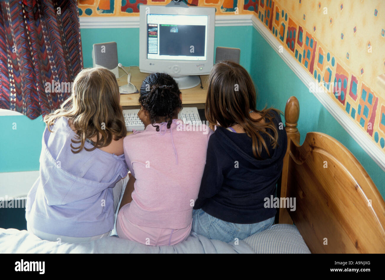 3 teenage girls watching something on computer screen Stock Photo - Alamy