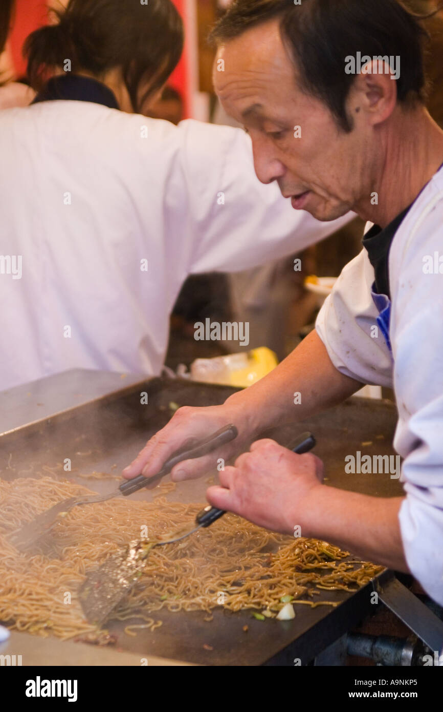 A vendor cooking yaki soba fried noodles at a food stand at Sensoji aka ...