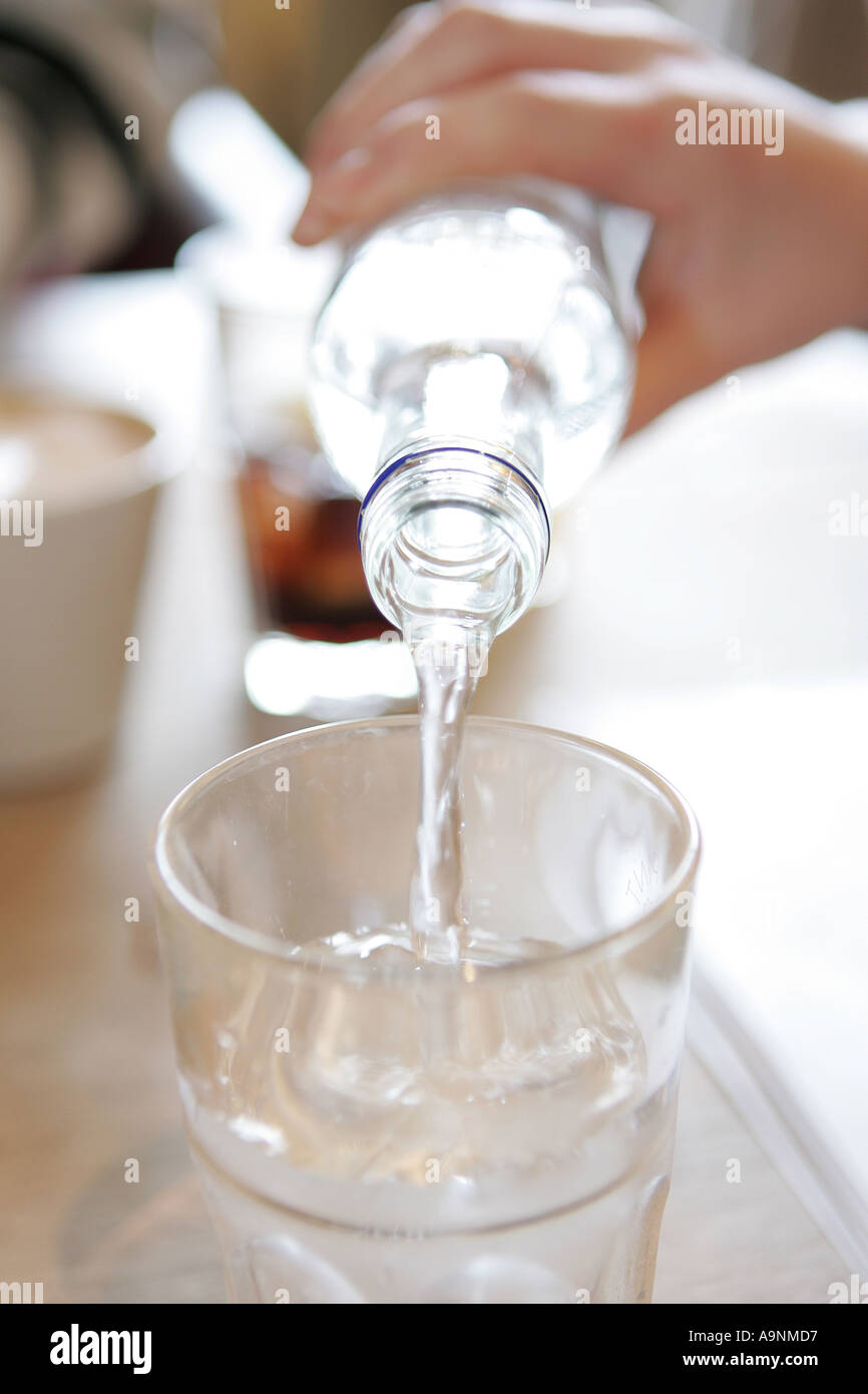 Bottle Of Spring Water Being Poured Into A Glass Stock Photo - Alamy