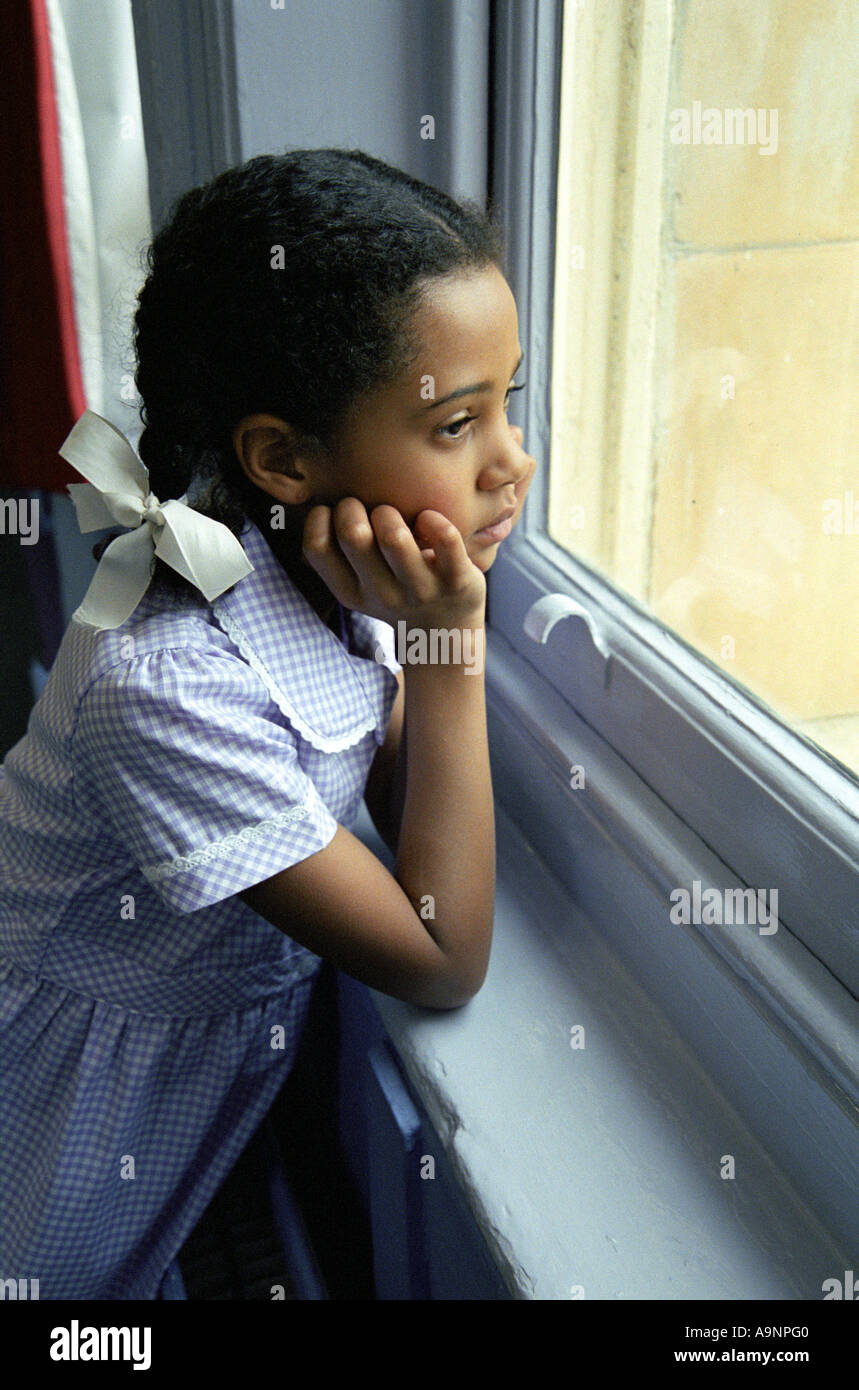 Schoolgirl looking out of a window Stock Photo - Alamy