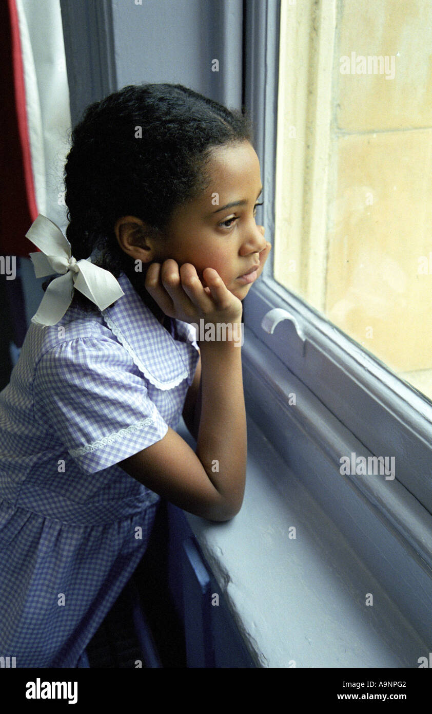 Schoolgirl looking out of a window Stock Photo - Alamy