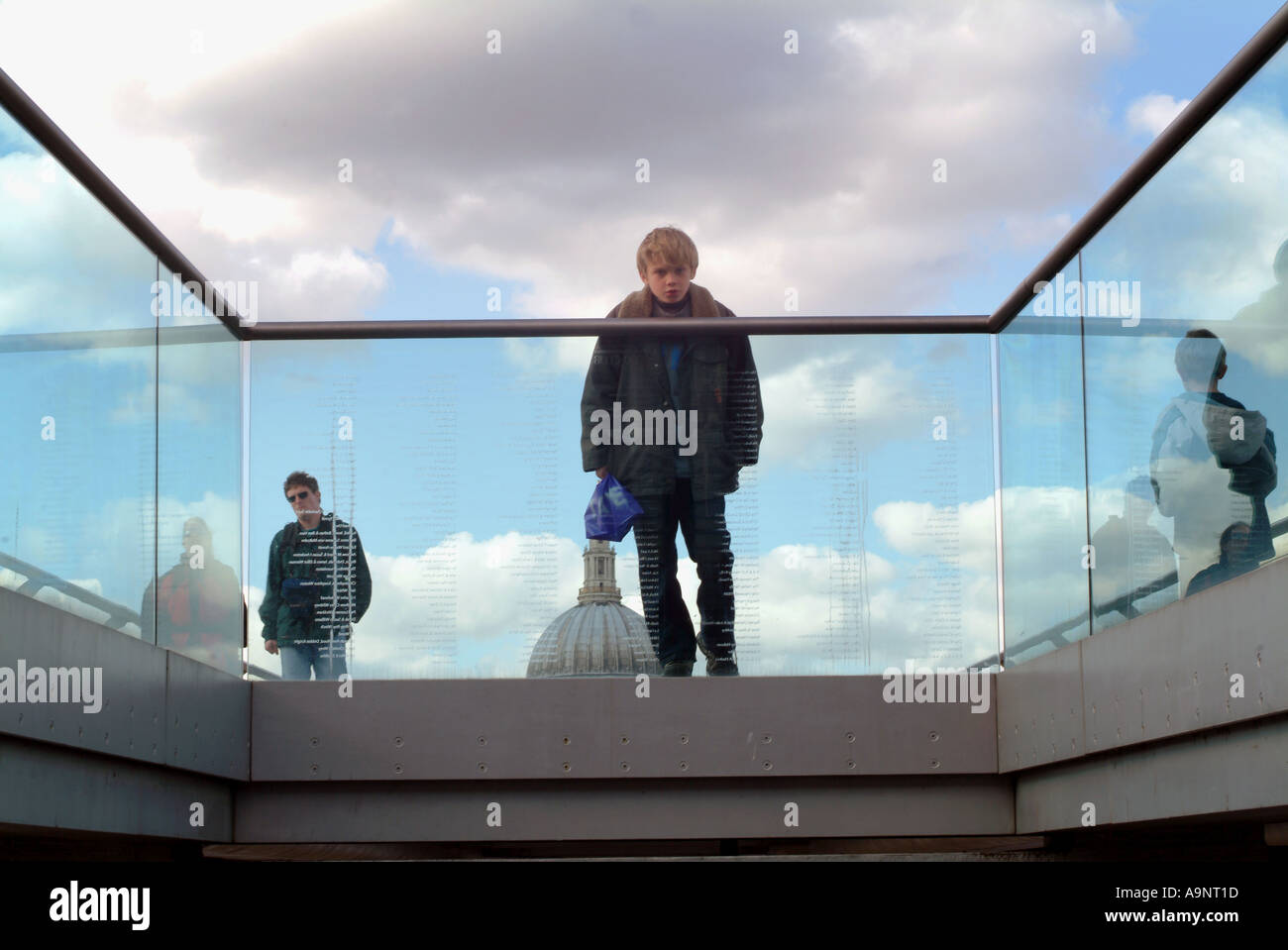 BOY LOOKING DOWN FROM THE BRIDGE WITH GREAT INTEREST Stock Photo - Alamy