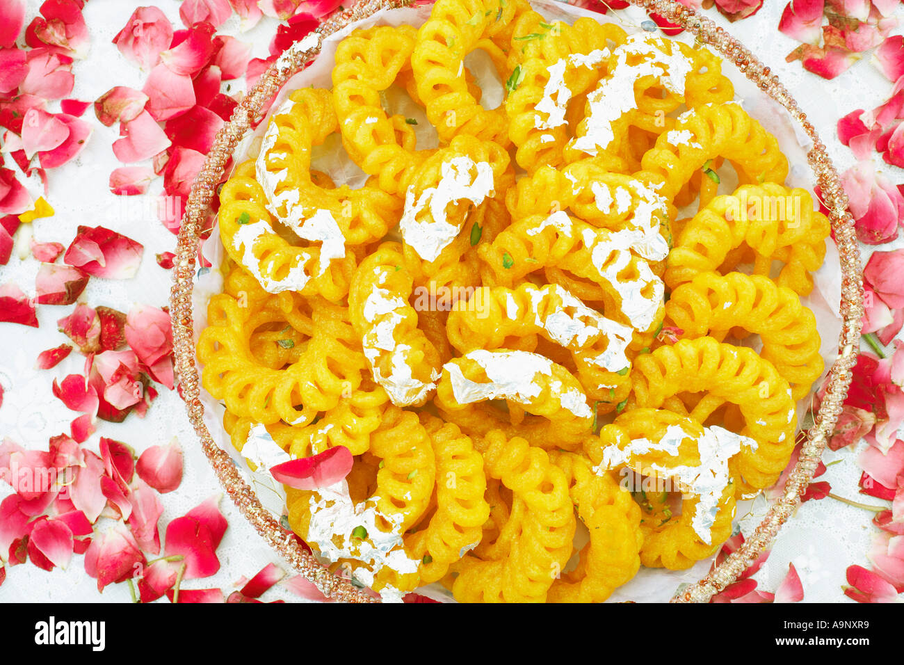 Close-up of a dish of Indian sweets with flower petals around it Stock ...