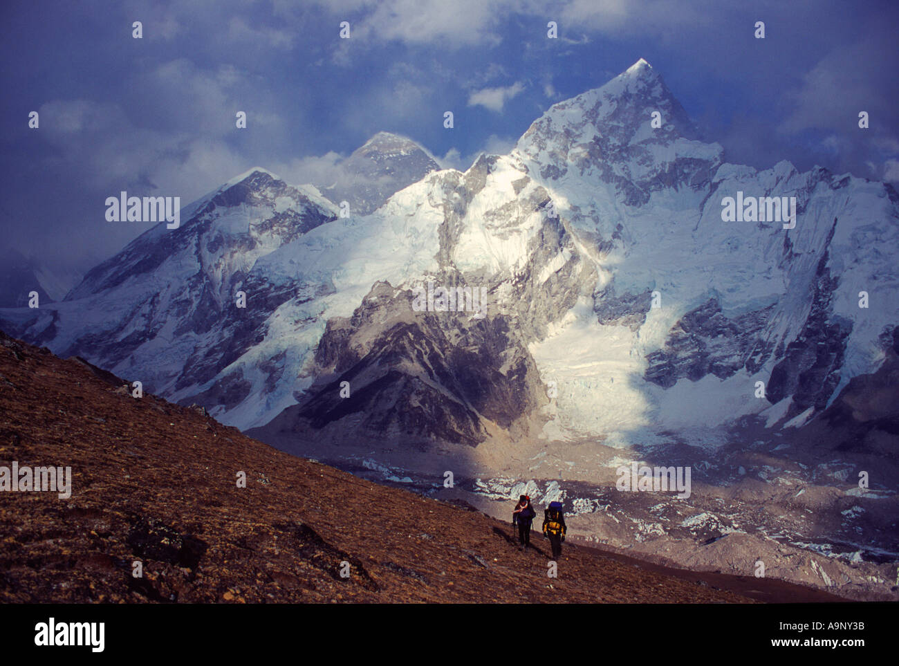 A couple hiking to the top of Kala Patar with Mount Everest in the ...