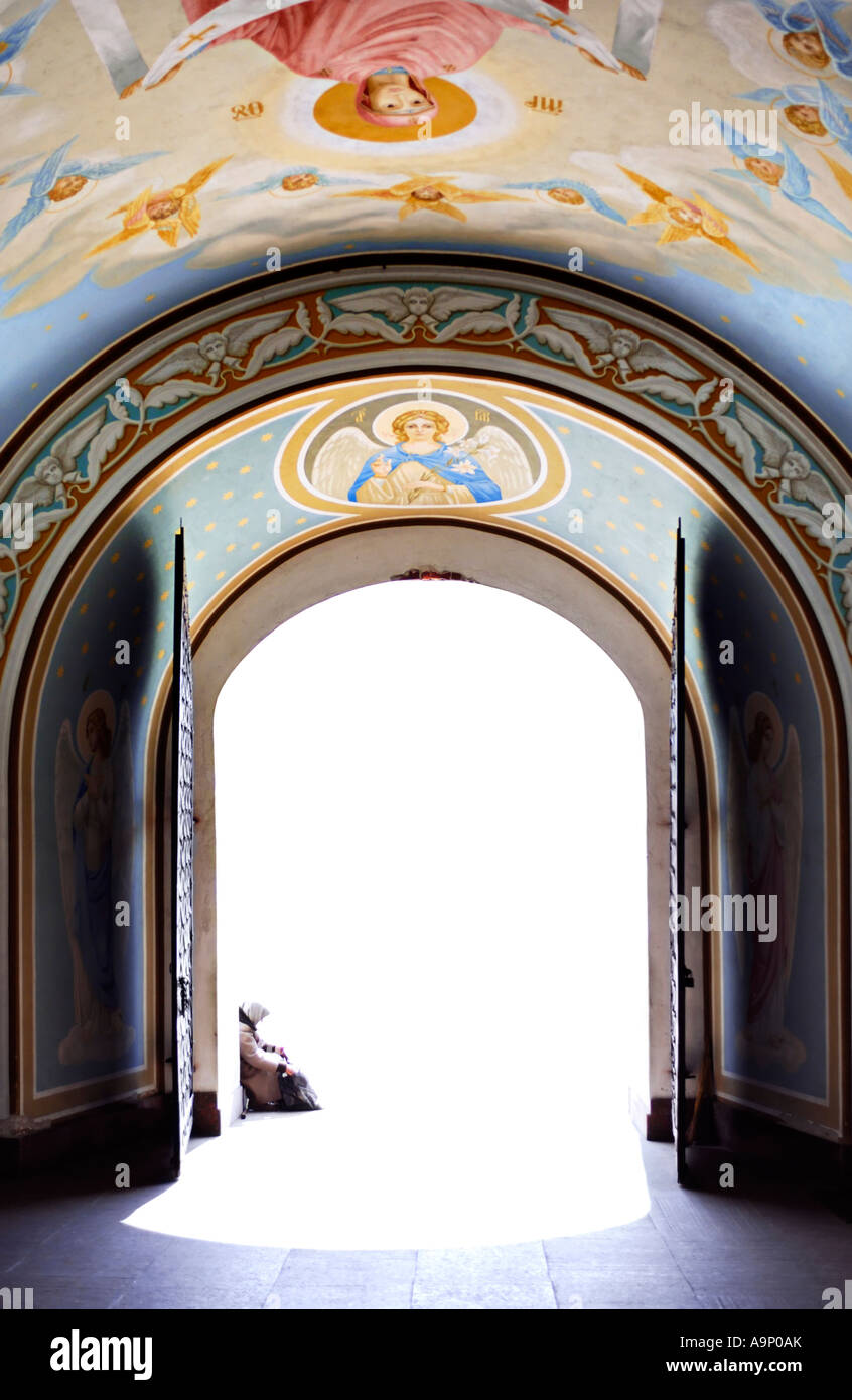 Old woman behind open cathedral gates Stock Photo - Alamy