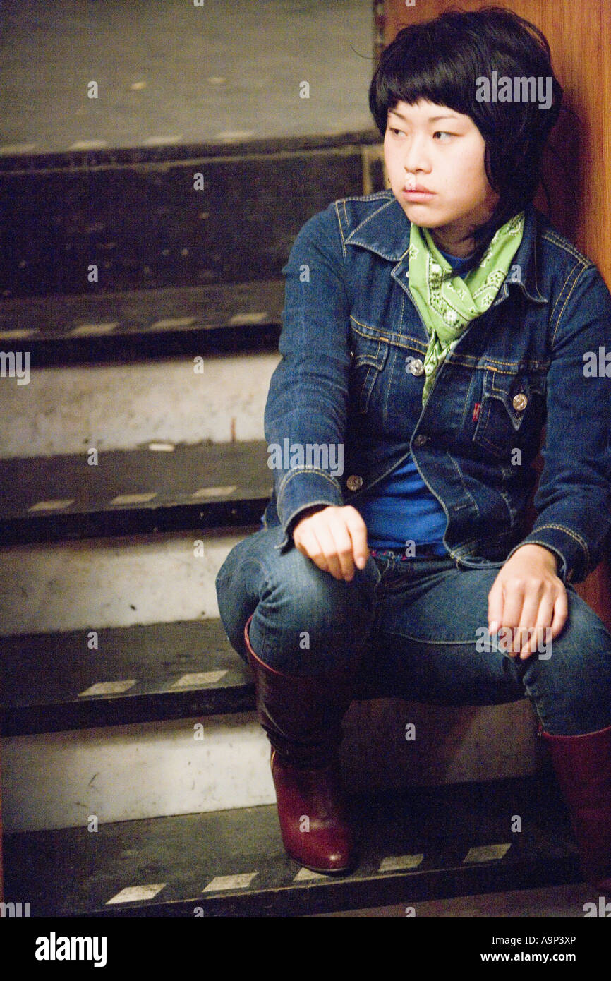 View of a young Asian woman sitting on steps Stock Photo - Alamy