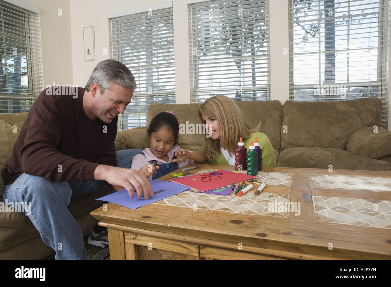 Parents helping their daughter to draw Stock Photo - Alamy