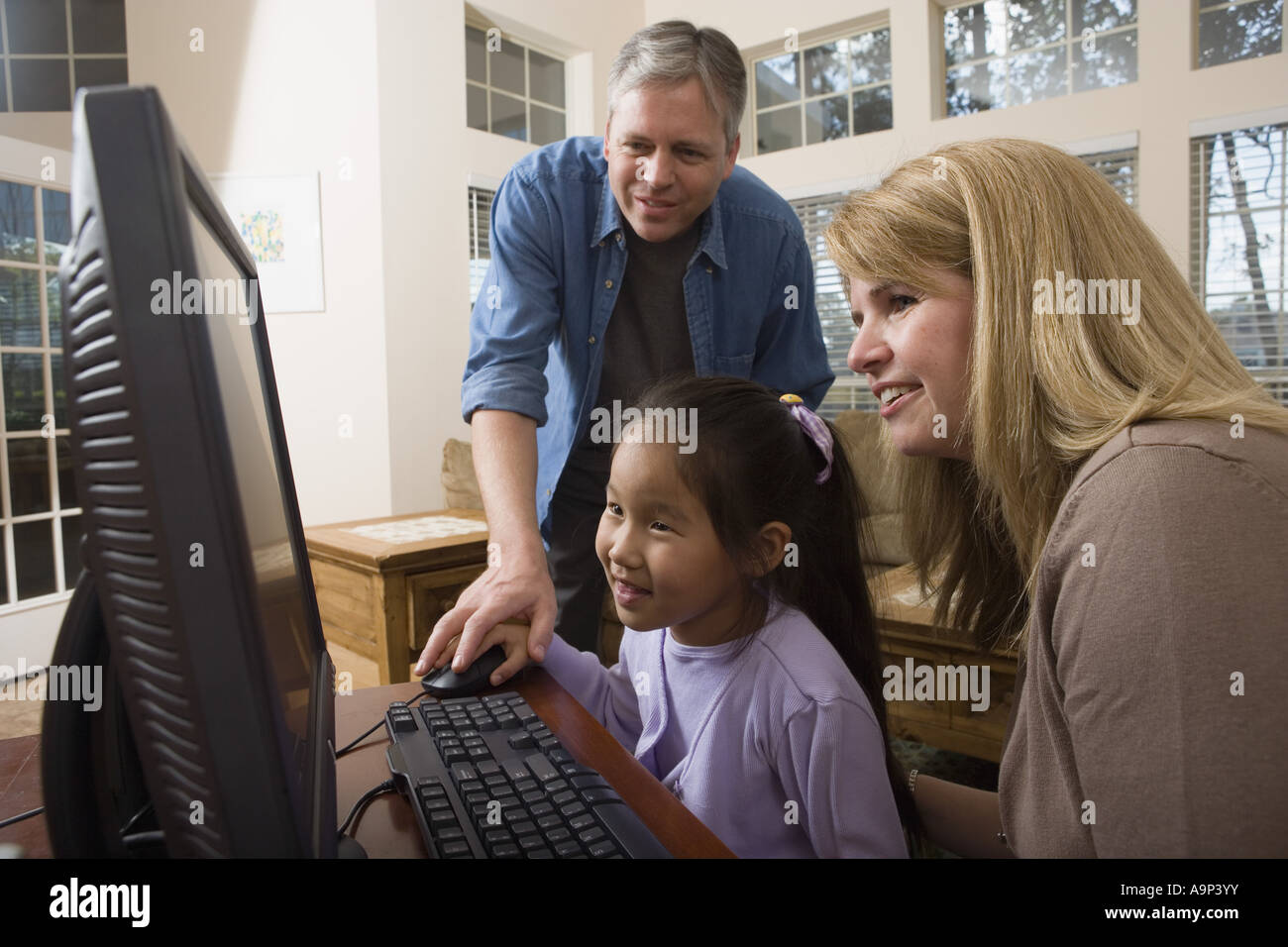 Parents with their daughter using computer Stock Photo - Alamy