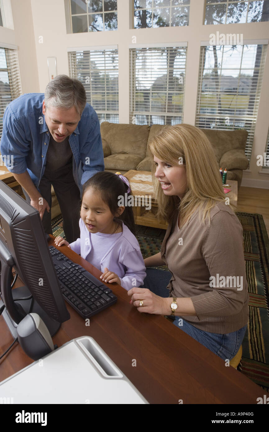 Parents with their daughter using computer Stock Photo - Alamy