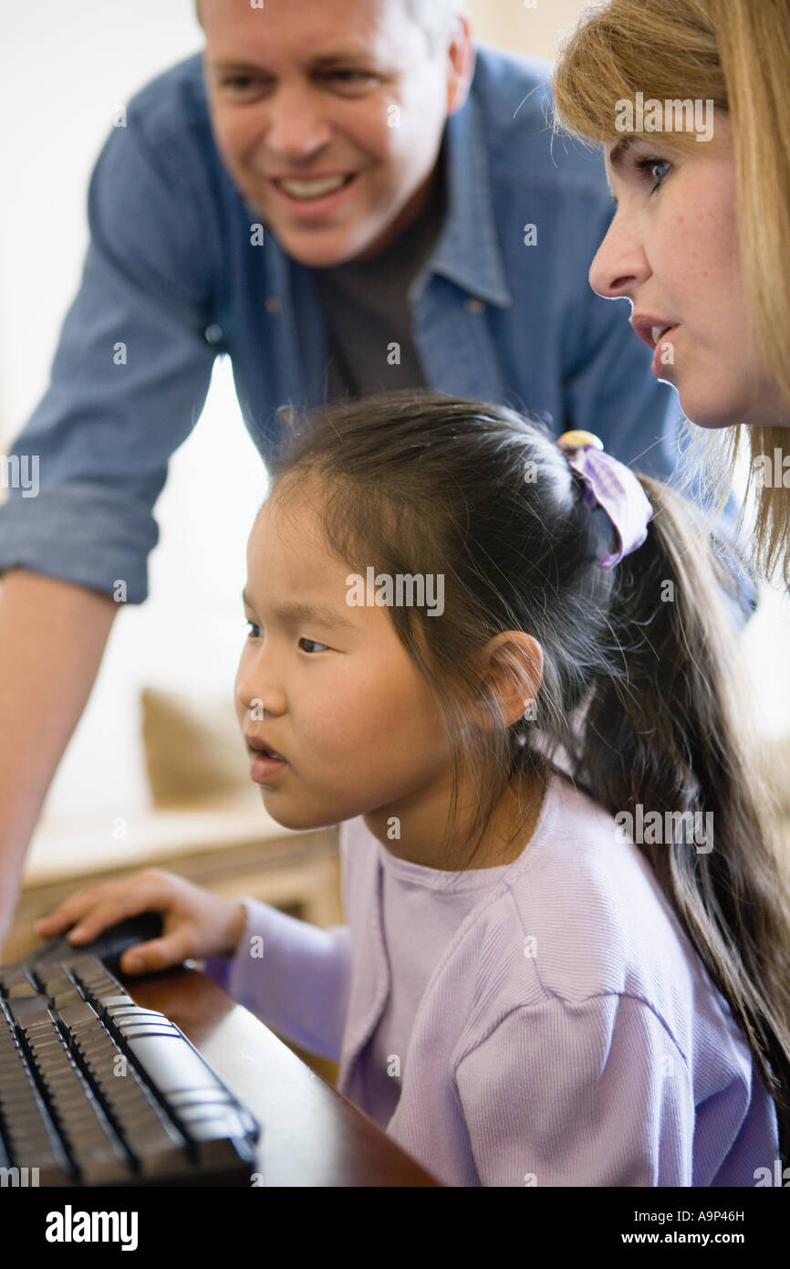 Parents and daughter looking at a computer Stock Photo - Alamy