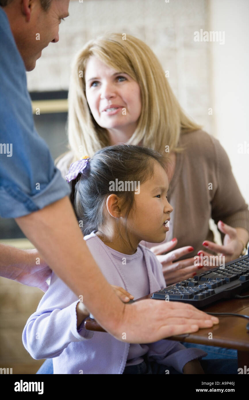 Parents with daughter working on a computer Stock Photo - Alamy