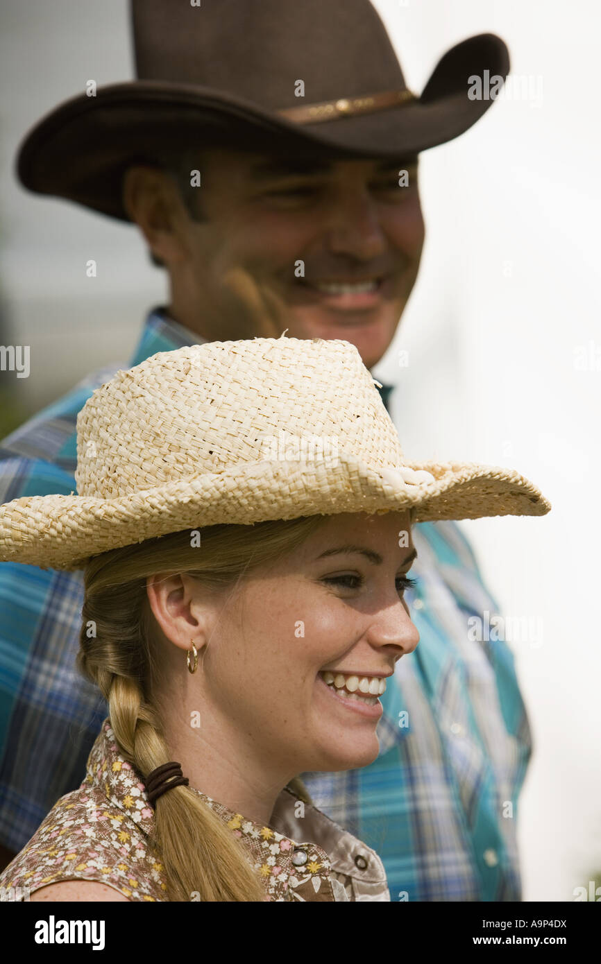 Close-up view of a young woman with her father wearing cowboy hats ...