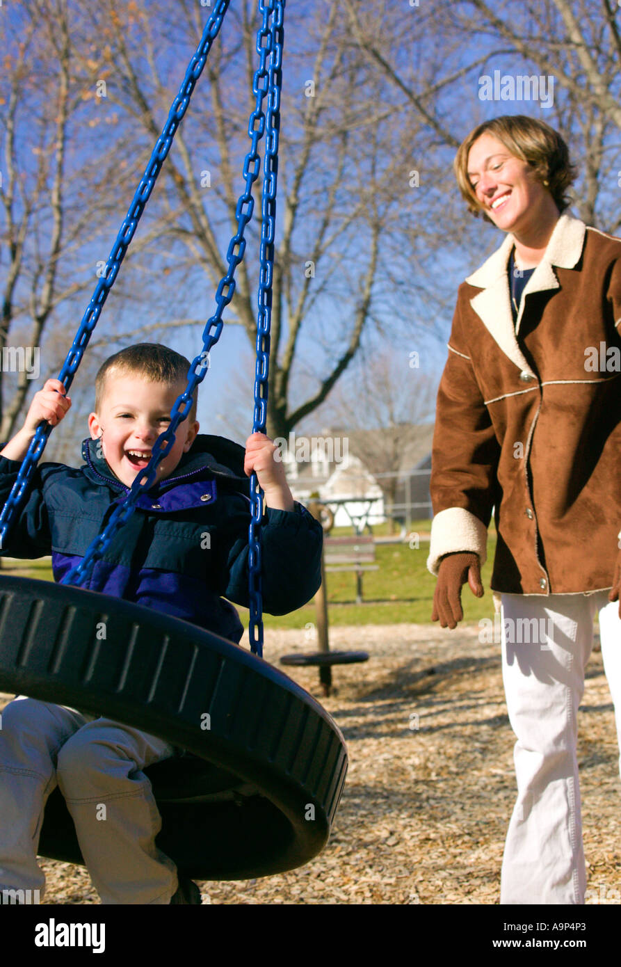 Kids on swing pushing hi-res stock photography and images - Alamy