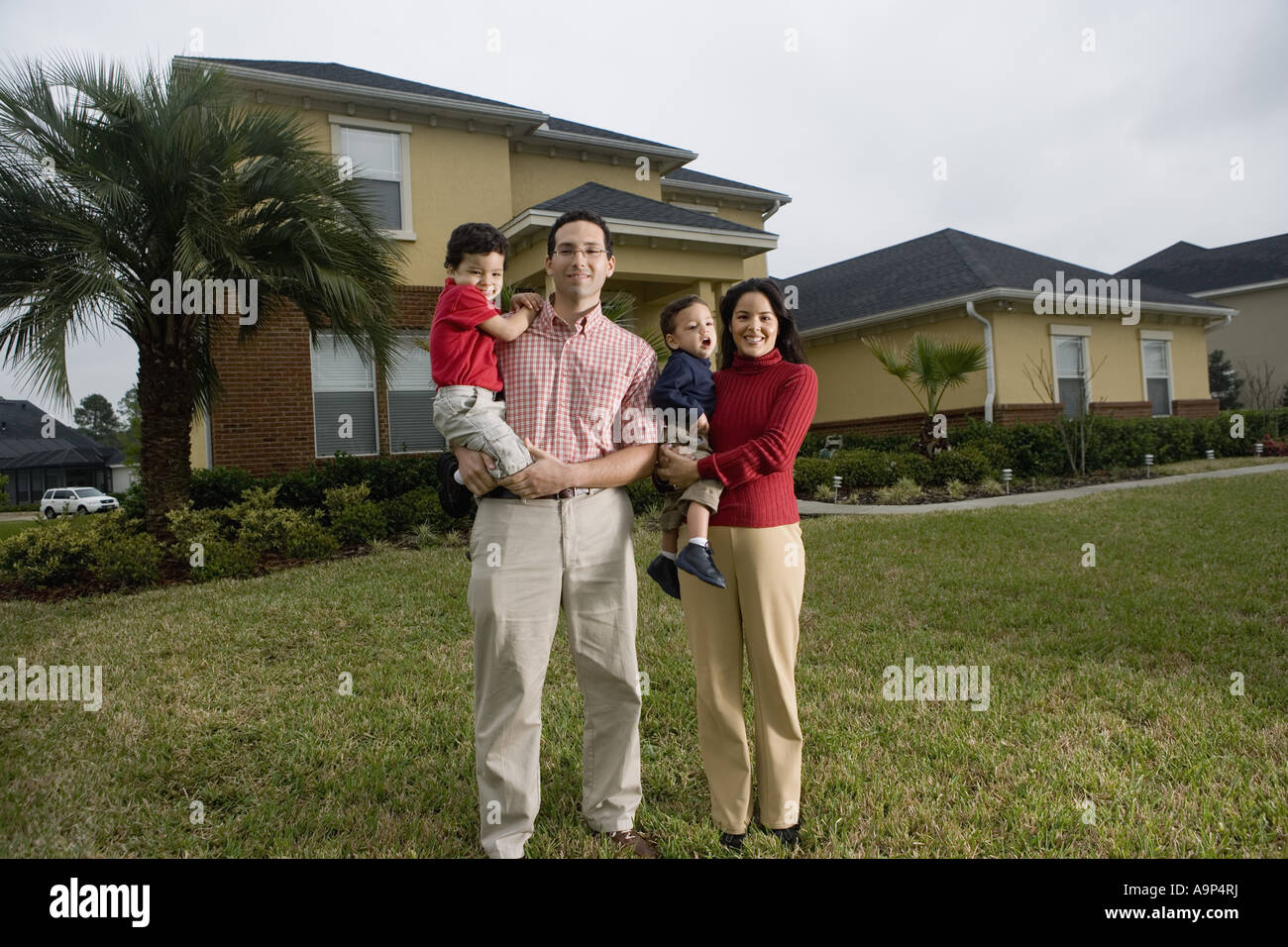 Portrait of family standing outside house Stock Photo - Alamy