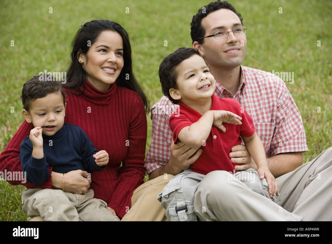 Hispanic family sitting on grass Stock Photo - Alamy