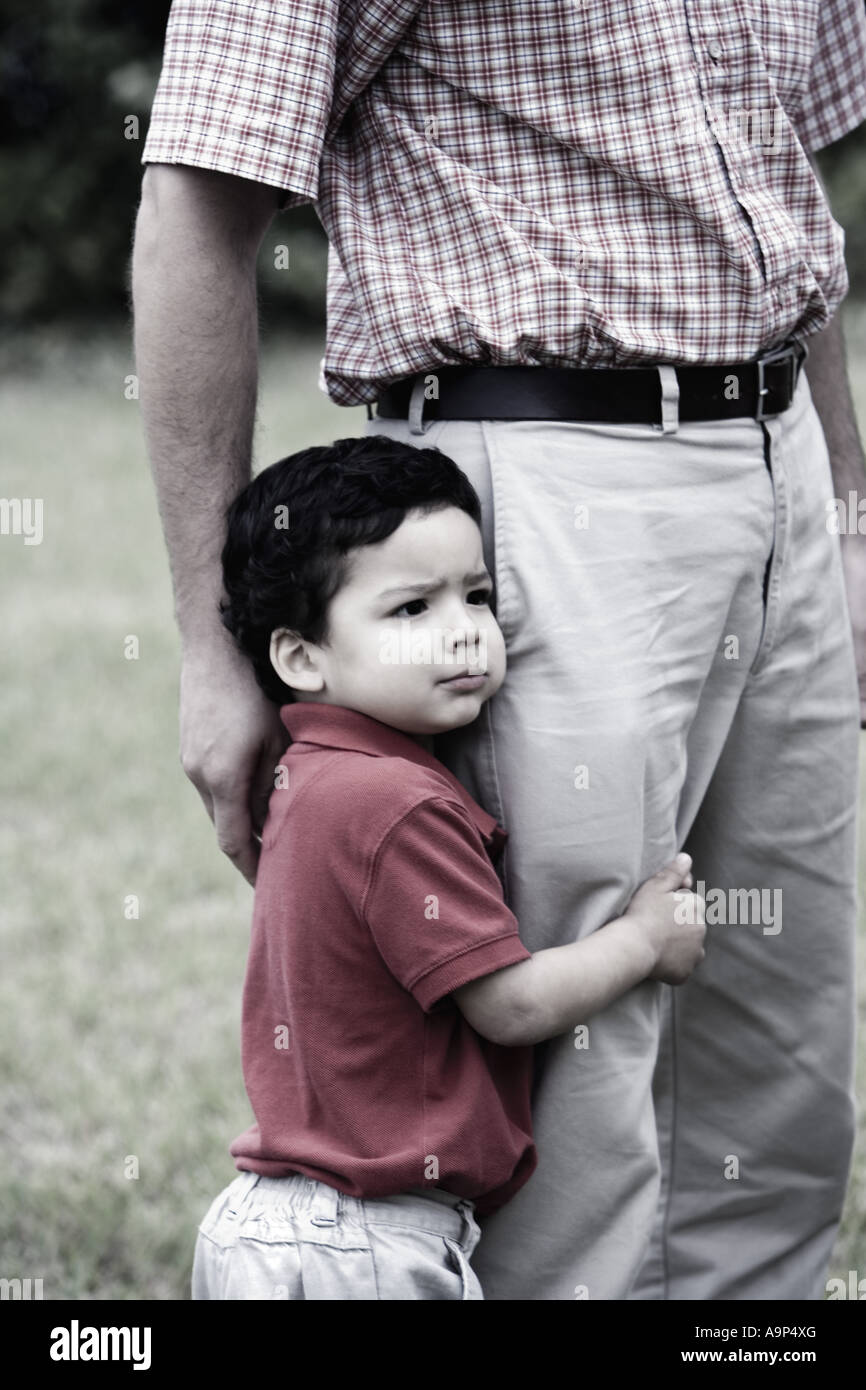 Son holding his father by his leg Stock Photo - Alamy