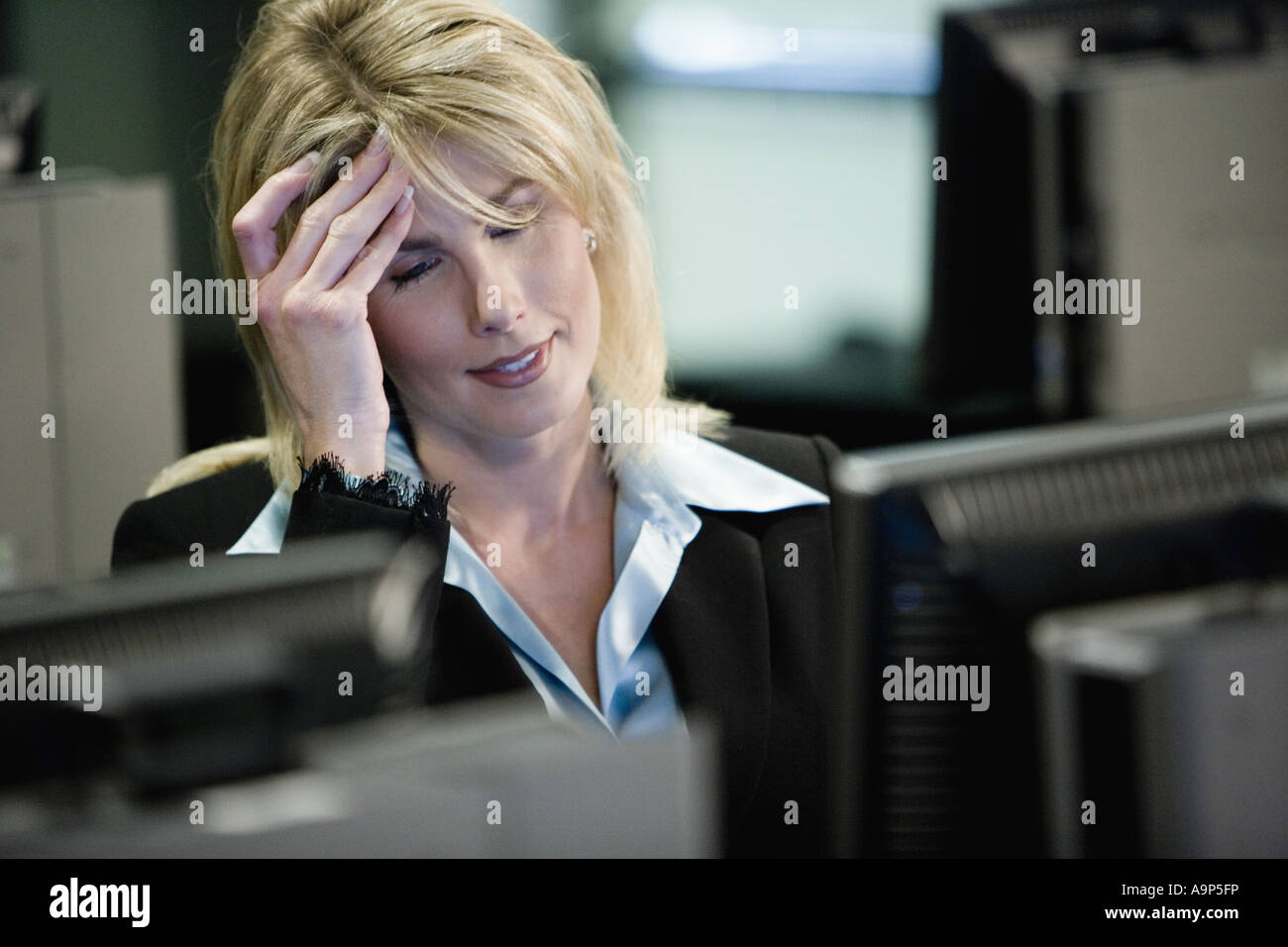 Businesswoman suffering from a headache working in an office Stock ...