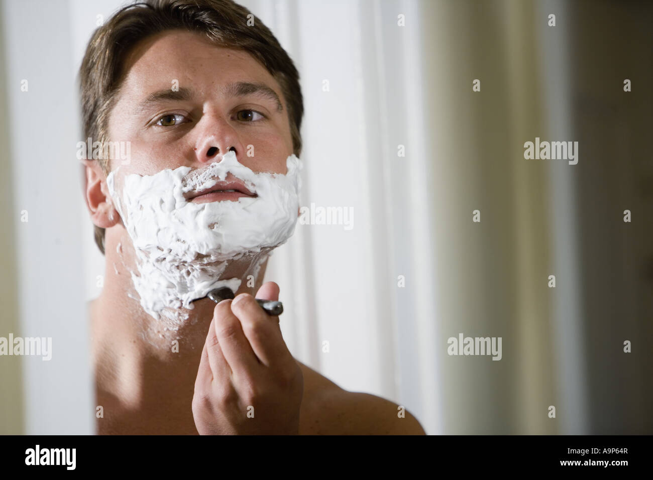Young man shaving Stock Photo - Alamy
